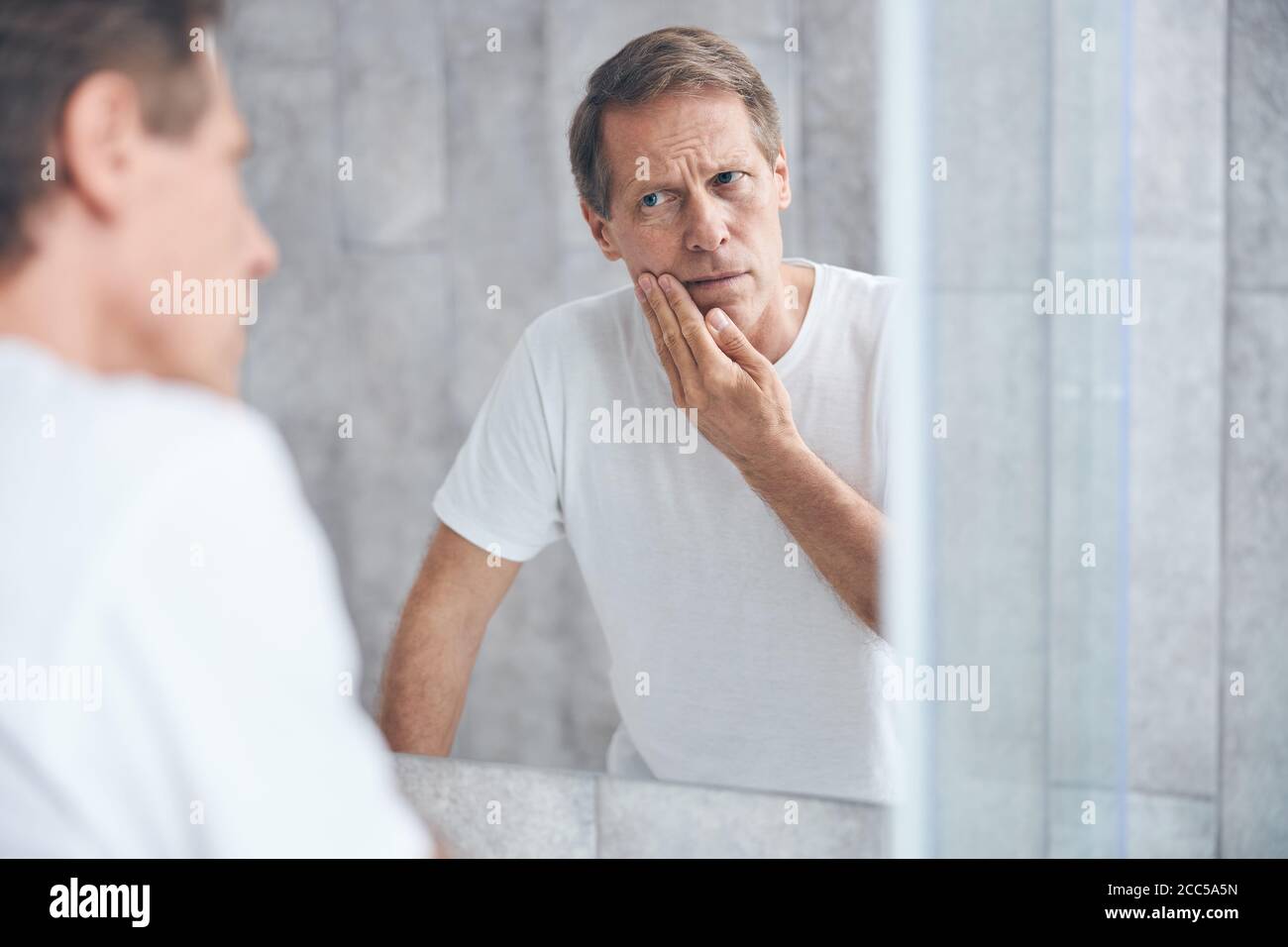 Sad man staring at his own reflection Stock Photo - Alamy