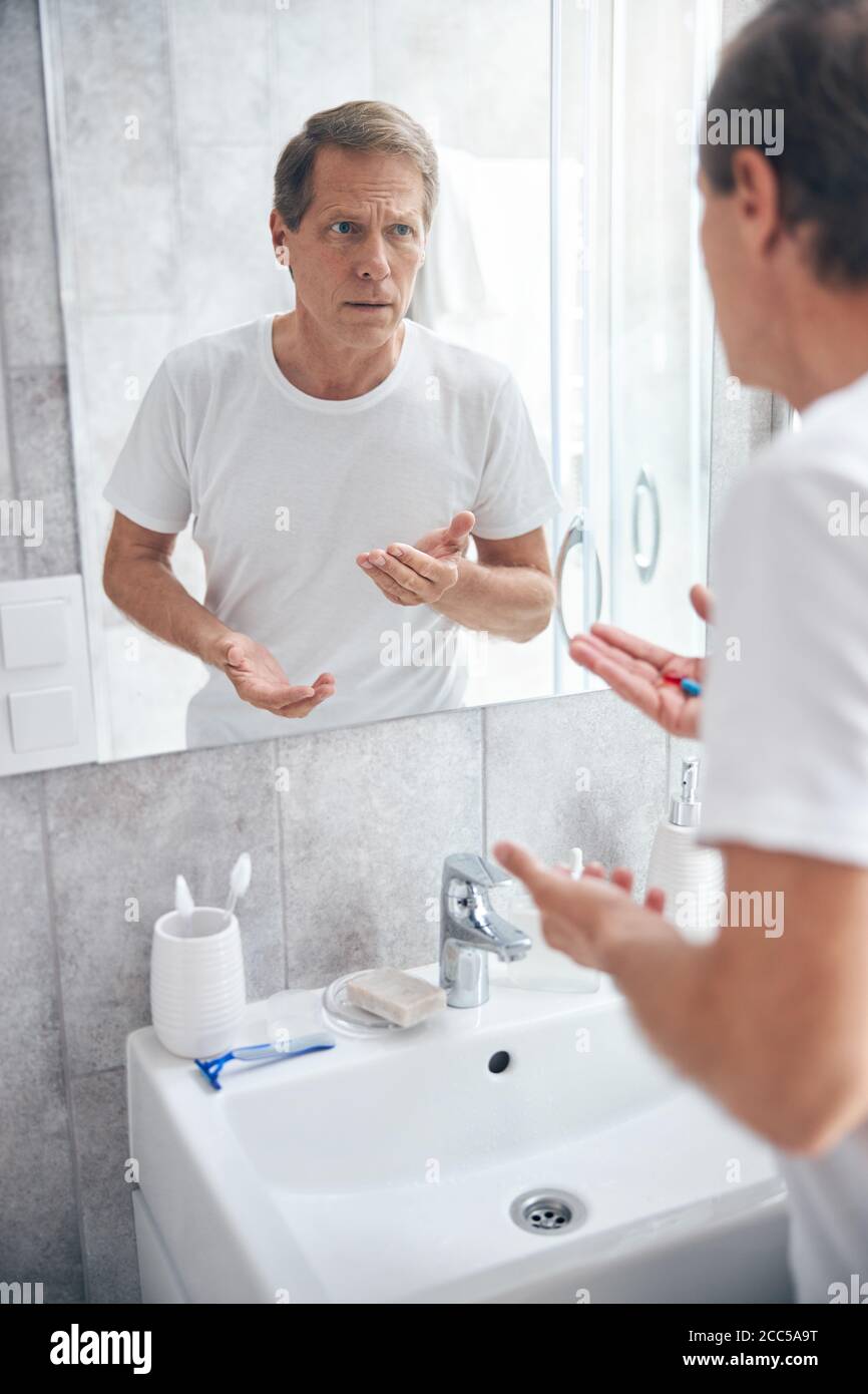 Tense man holding tablets in his palm Stock Photo - Alamy