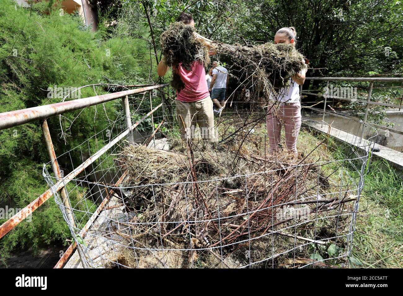 Organic composter. People are making bio composter bin in a yard Stock ...