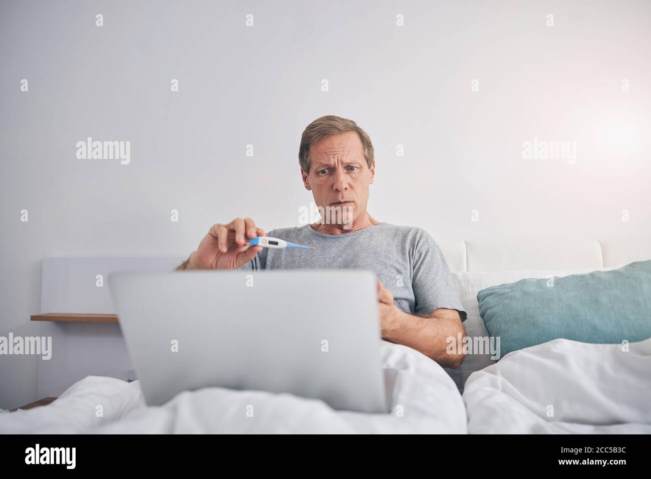 Attentive male person staring at screen of his laptop Stock Photo - Alamy