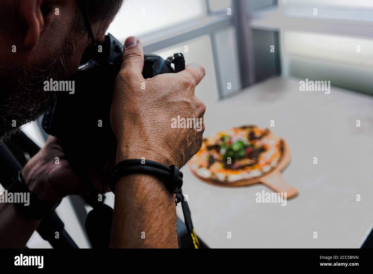 High angle shot of a person taking a photo of a pizza on the table ...