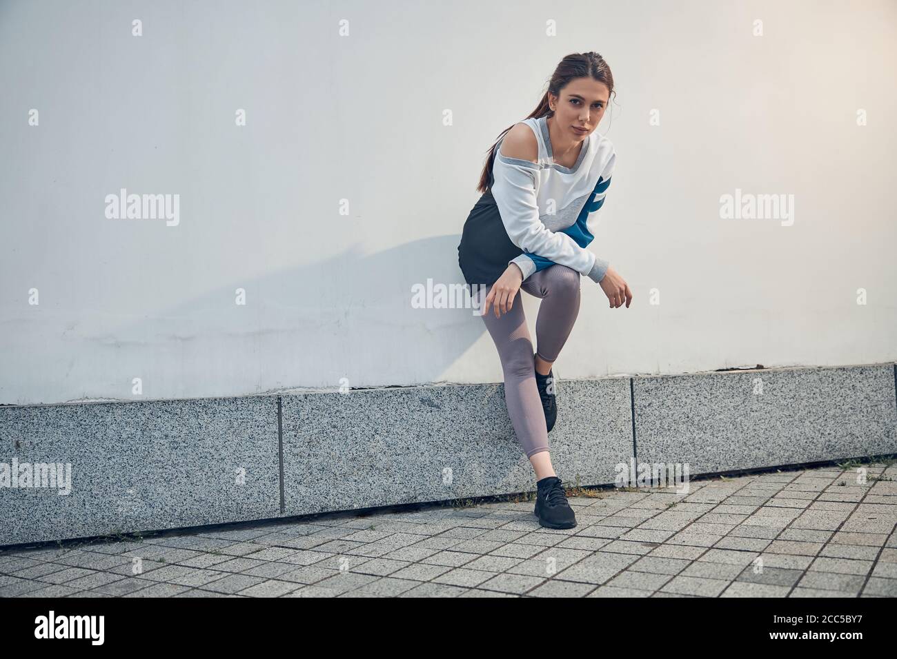Calm fit lady in sportswear staring ahead Stock Photo - Alamy