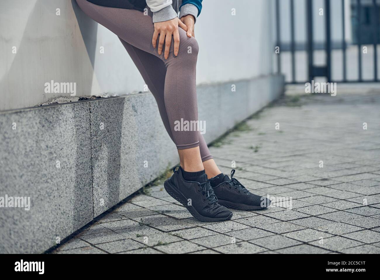 Woman experiencing a pain in her knee joint Stock Photo - Alamy