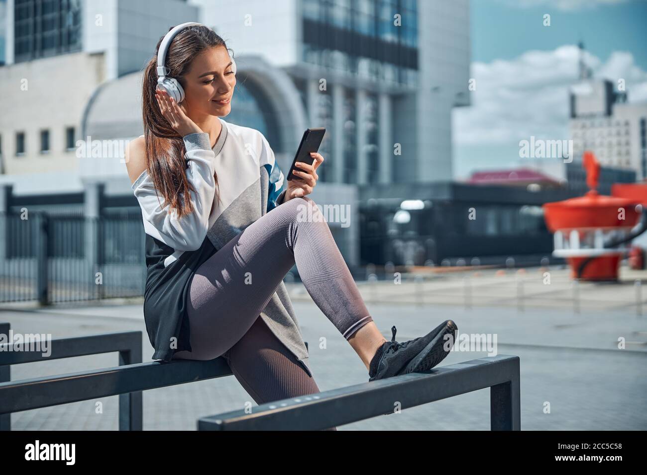 Pleased woman gazing at her mobile phone Stock Photo - Alamy
