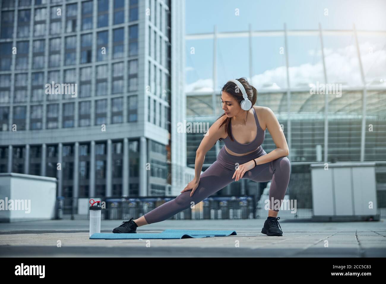 Fit dark-haired female performing a warm-up exercise Stock Photo - Alamy