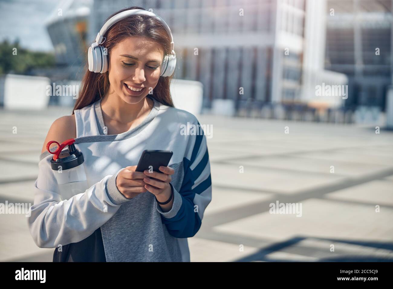 Woman in headphones reading a text message Stock Photo - Alamy