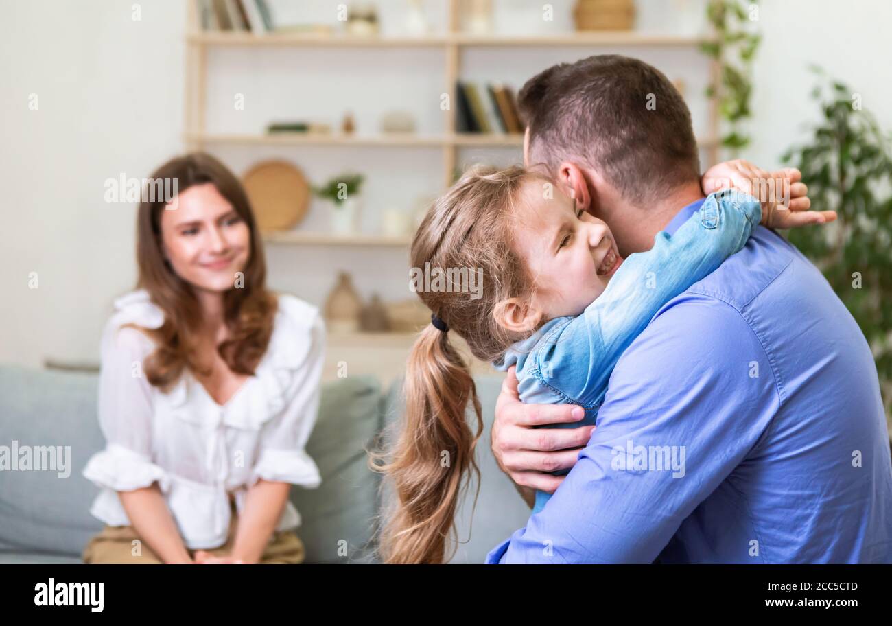Cute Dad And Daughter Hugging In Front Of Mother Indoor Stock Photo - Alamy
