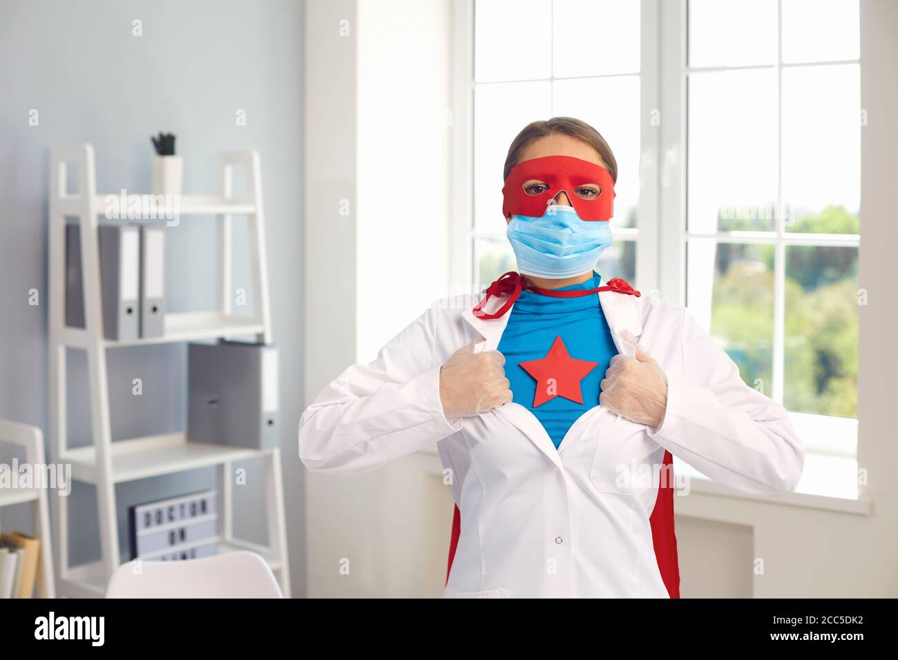 Female doctor showing superhero uniform in clinic Stock Photo - Alamy