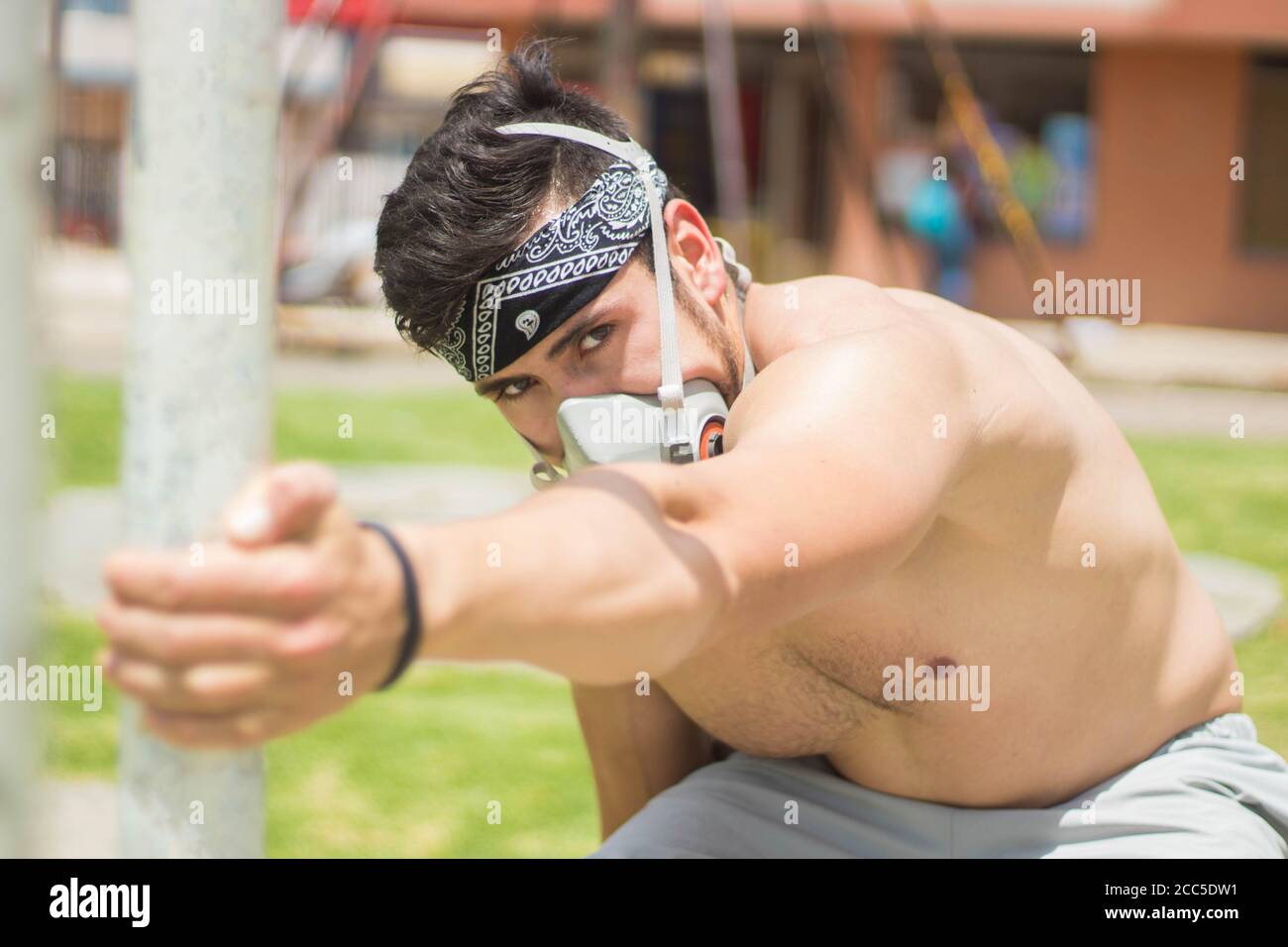 Athletic male with a face mask working out on a field during the day ...