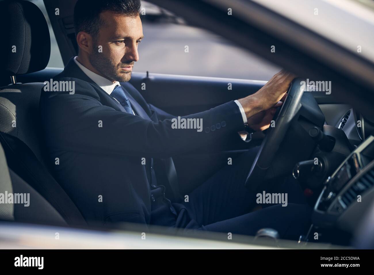 Young Caucasian male staying in car alone Stock Photo - Alamy