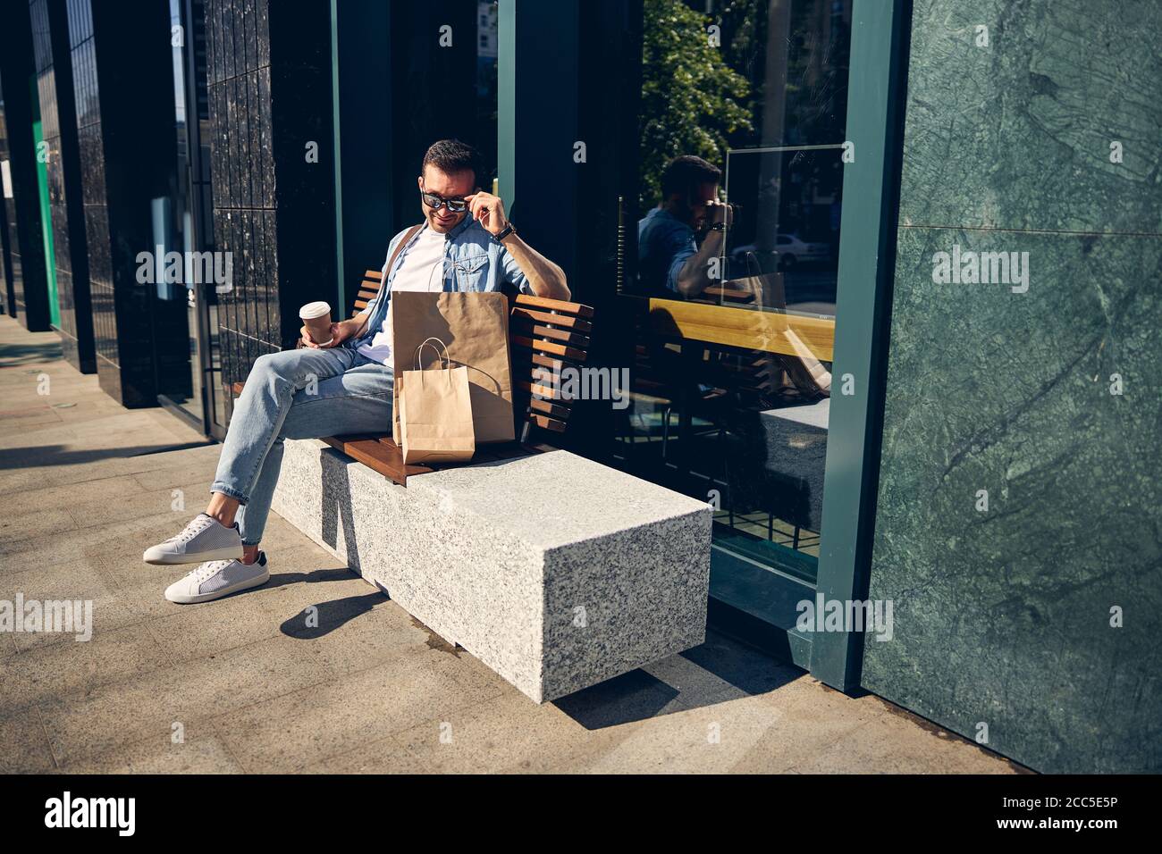 Tired young man sitting on the bench Stock Photo - Alamy