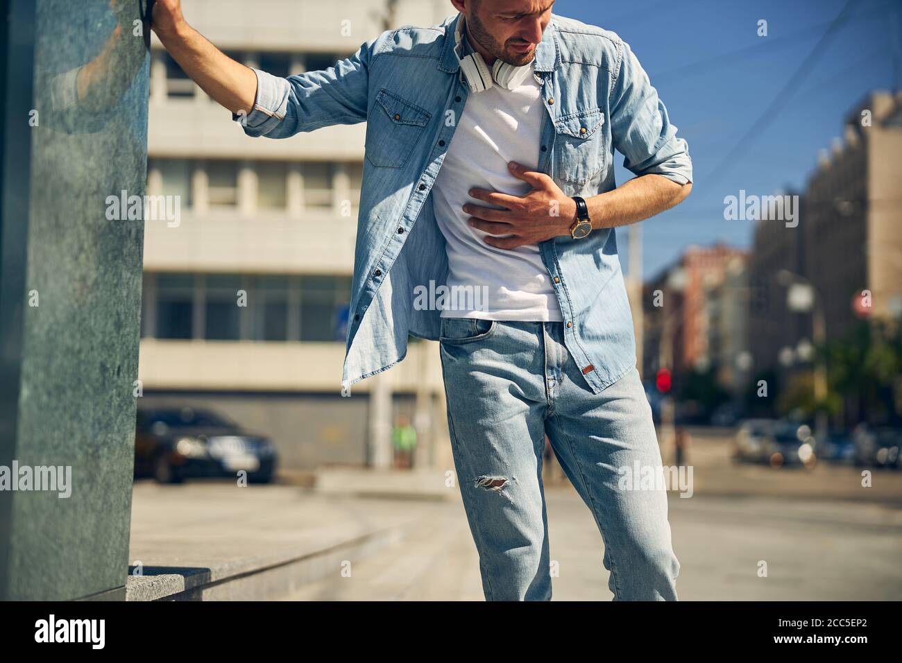 Negative delighted male person leaning on the wall Stock Photo - Alamy