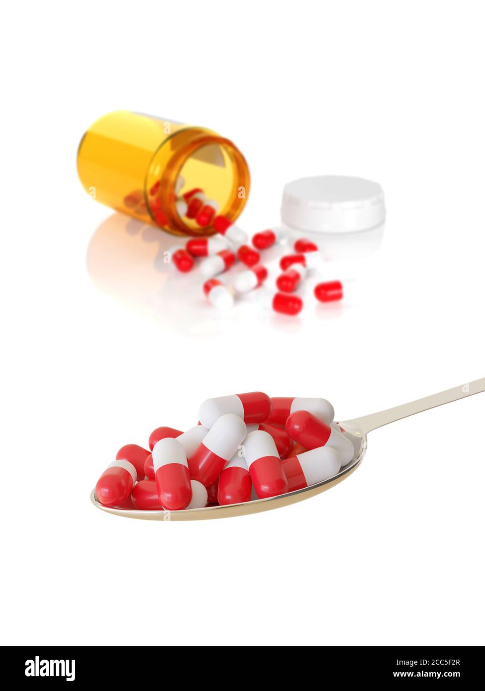 Spoon full of red and white pills and a pill bottle spilled isolated on ...