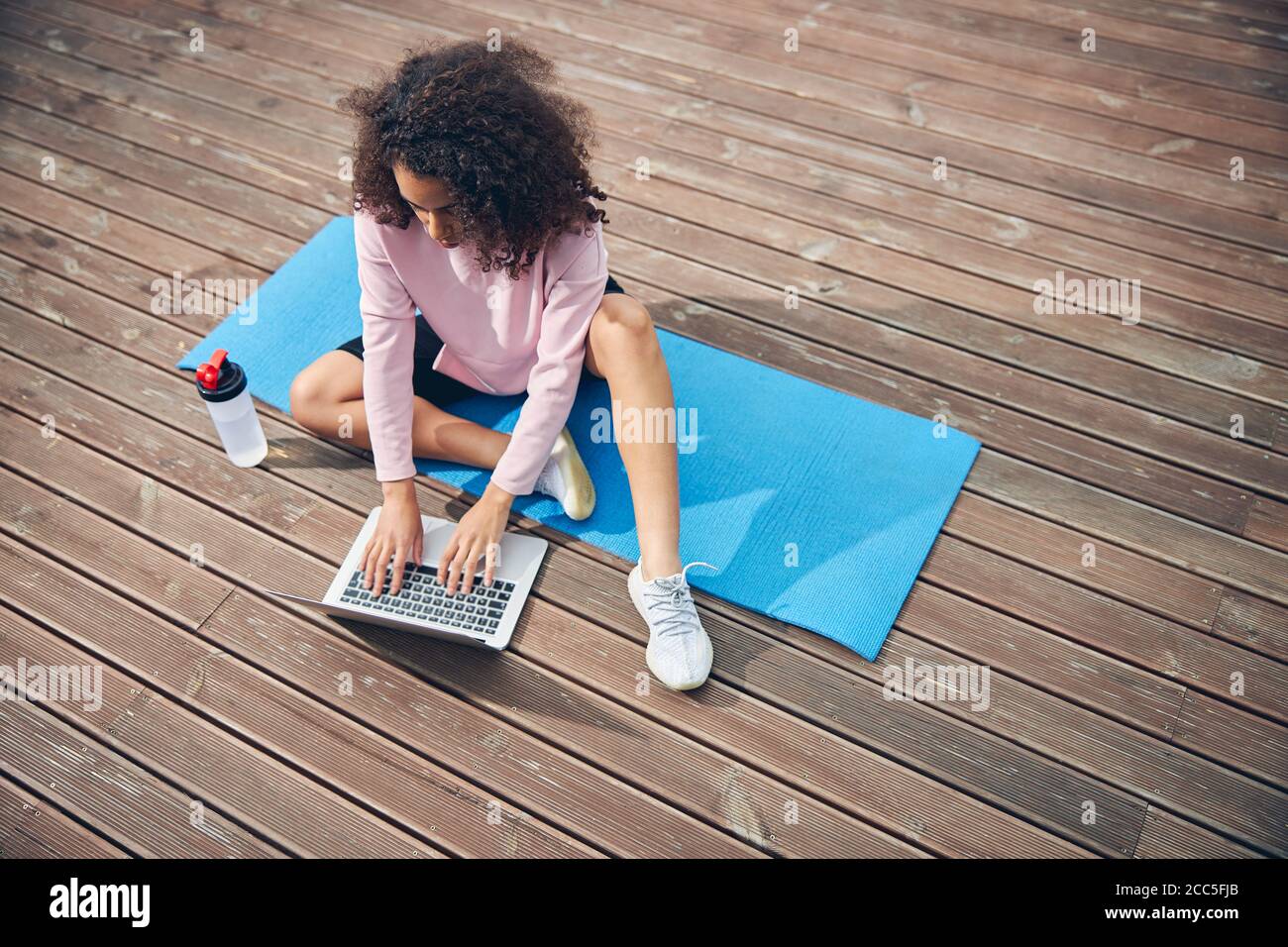 Woman with curly hair using computer for work Stock Photo - Alamy