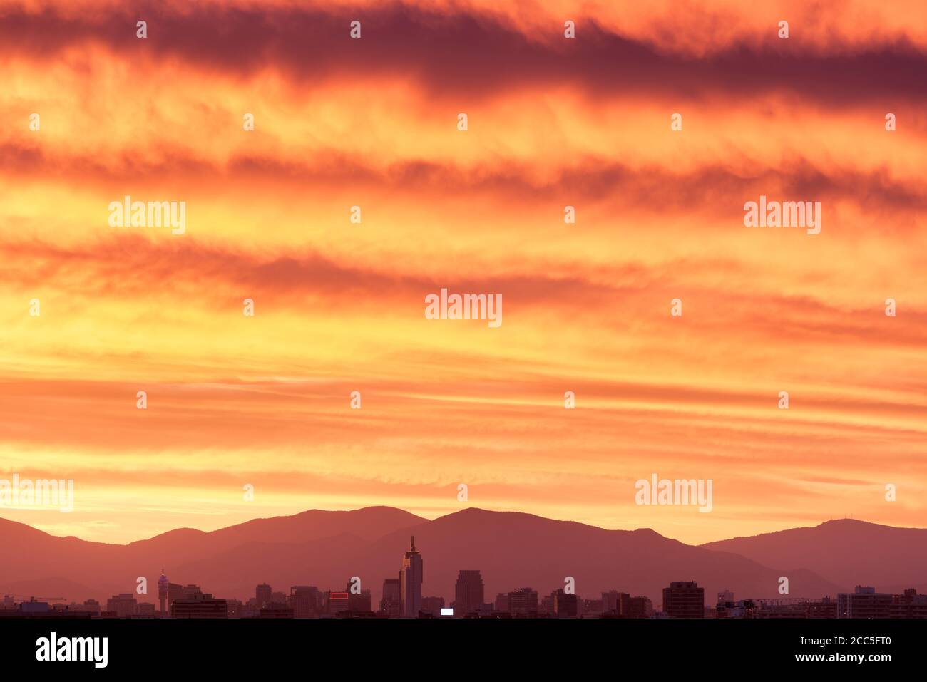 Skyline of downtown Santiago de Chile with a large cloudy sky at sunset ...