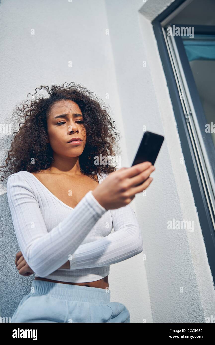 Cute young lady standing alone and looking anxious Stock Photo - Alamy