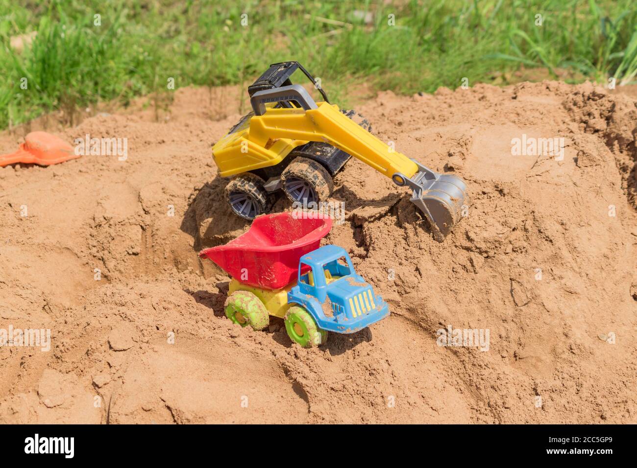 plastic toys in a sandbox outdoors. Truck and excavator for playing in ...