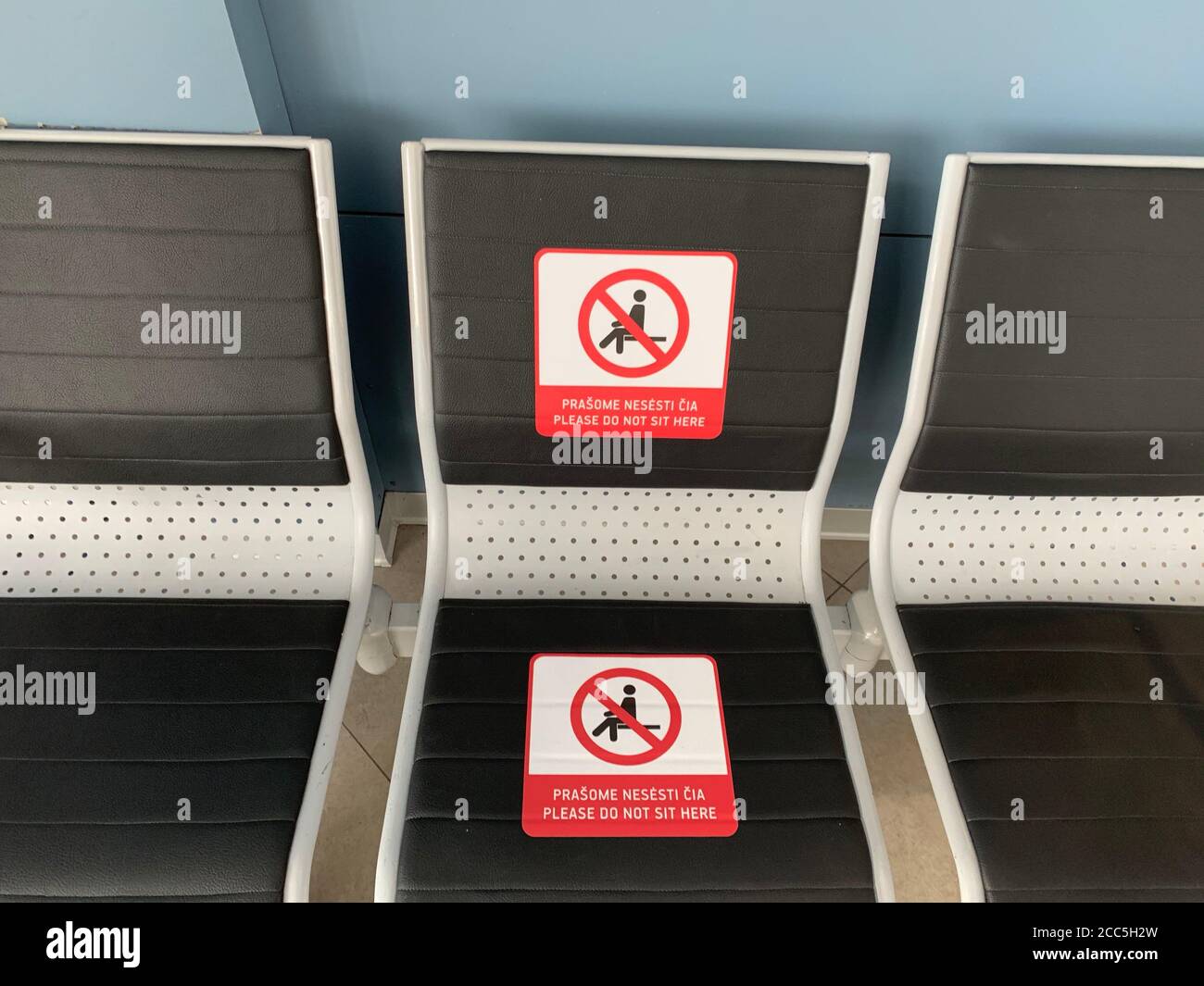 Please do not sit here sign on bench at Vilnius airport. Passengers ...
