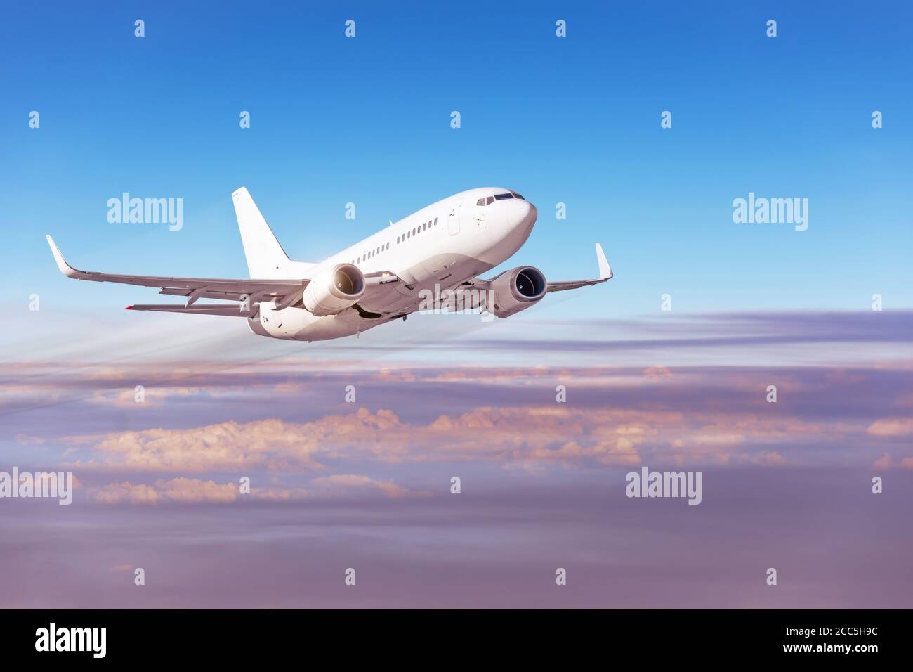 Evening sky with dense clouds and a passenger plane flying high at ...