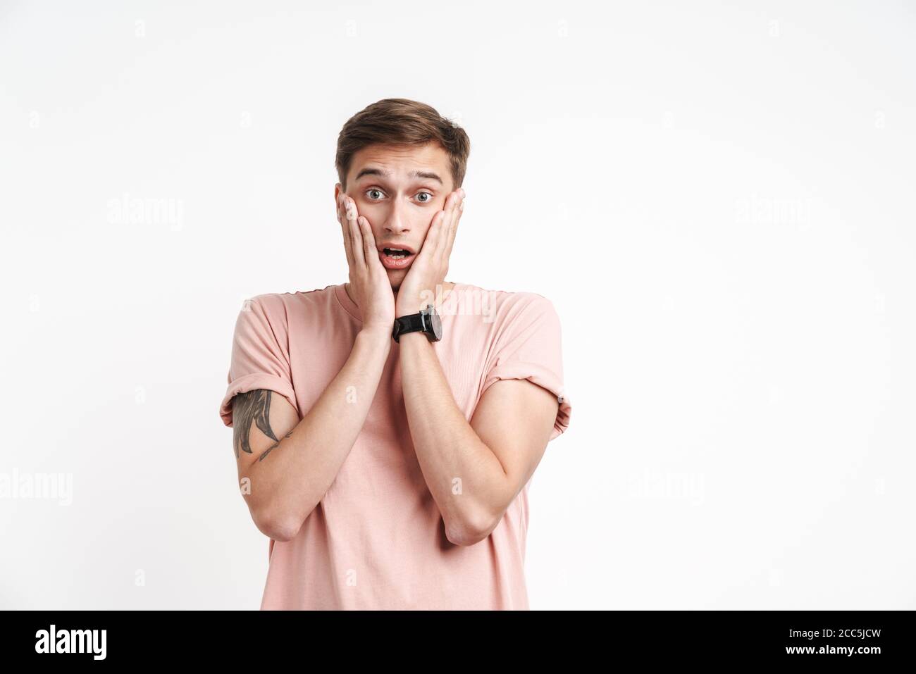 Image of intimidated caucasian man in basic t-shirt screaming and ...