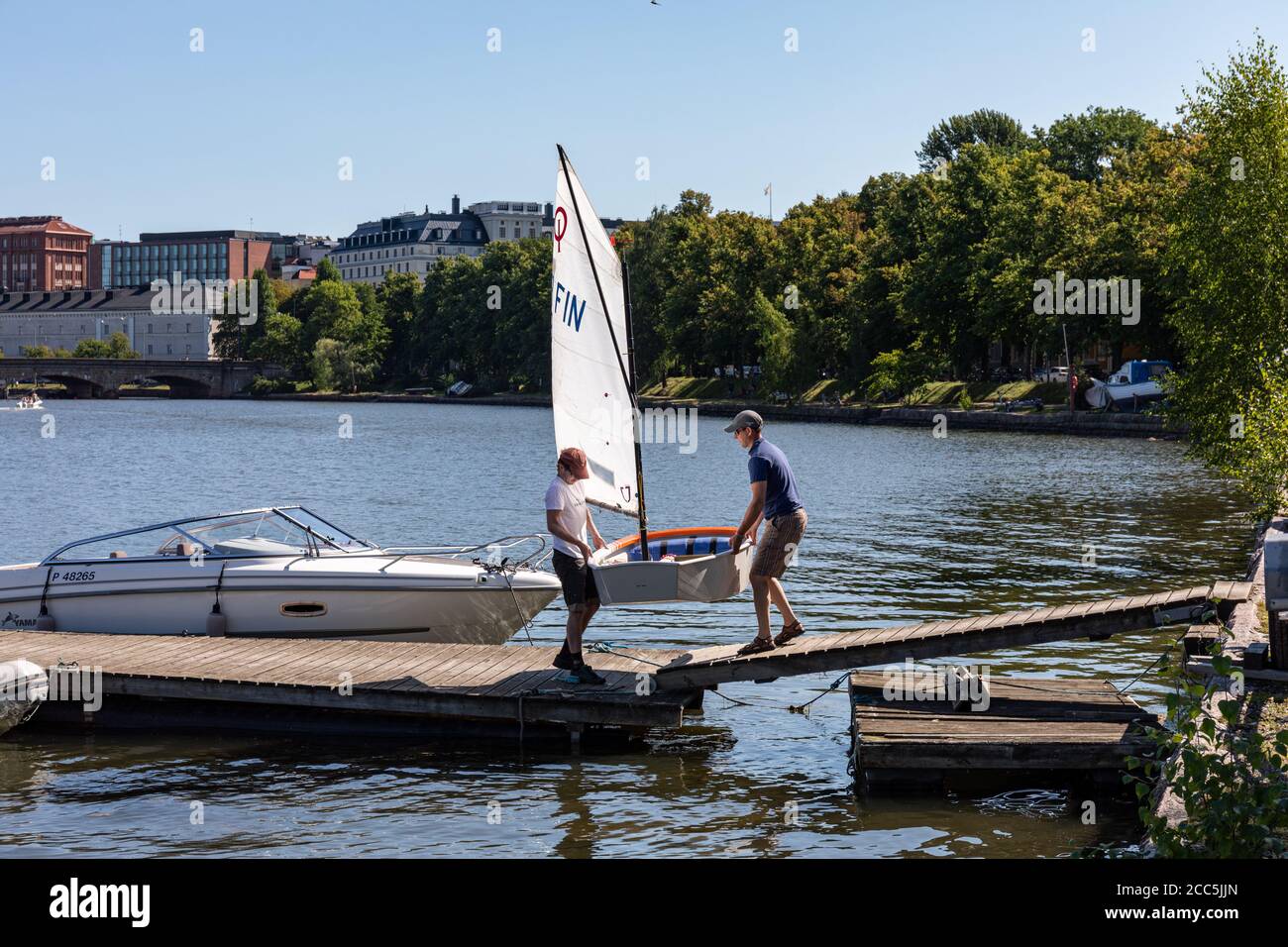 Men carrying a sailing skiff in Kaisaniemi district of Helsinki ...