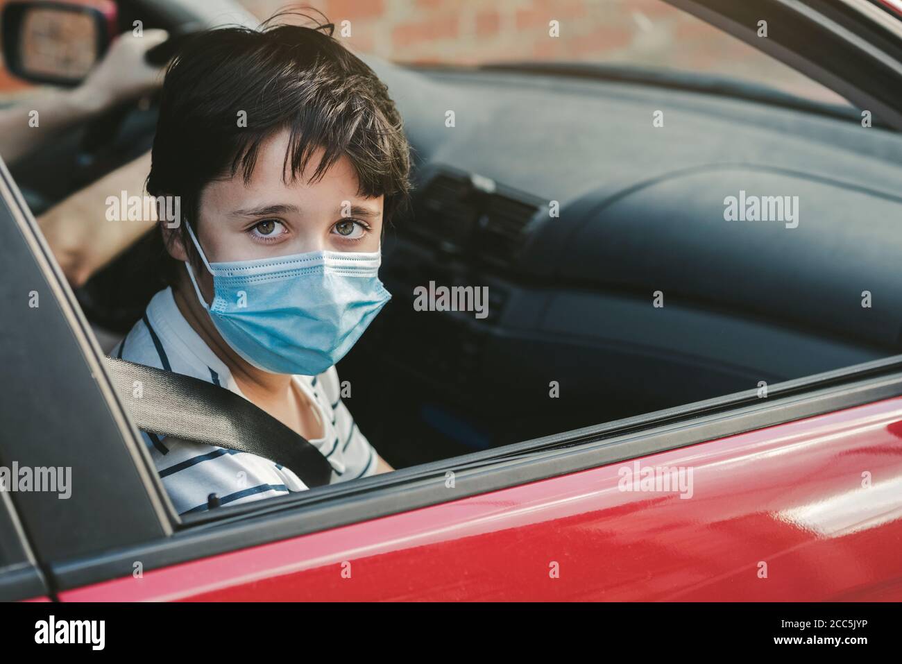 kid wearing medical mask riding in a car outdoor Stock Photo - Alamy