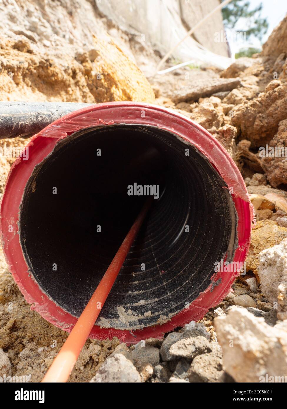 Detail of optic fiber wire in ribbed flexible red plastic tube, thin ...