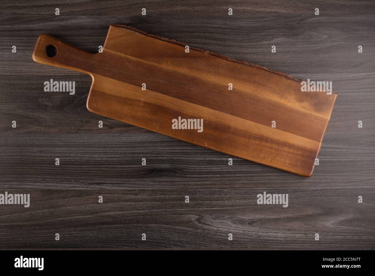 Top view of wooden cutting board on old dark wood countertop Stock ...