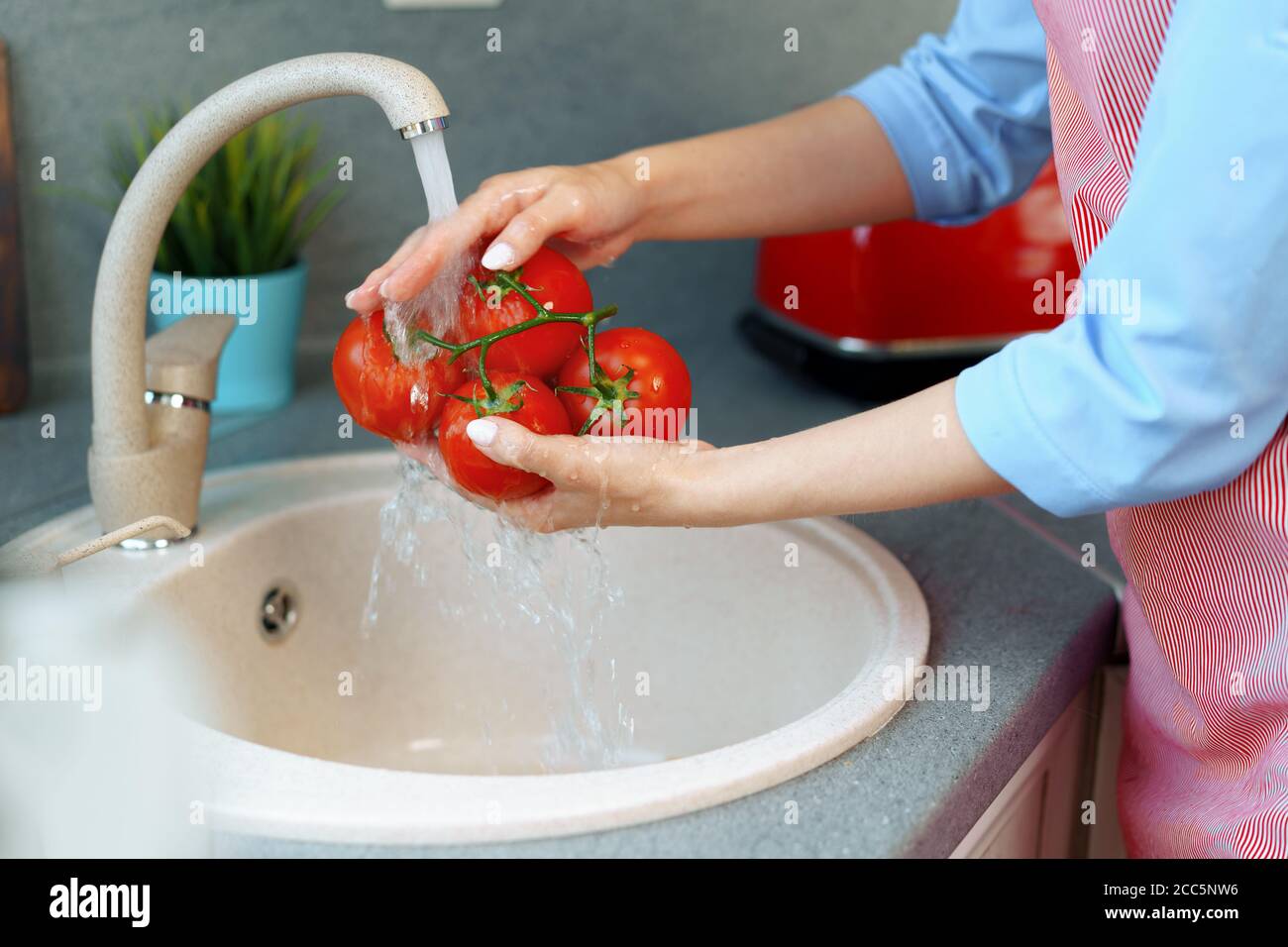 Close up photo of woman washing tomatoes in a sink Stock Photo - Alamy