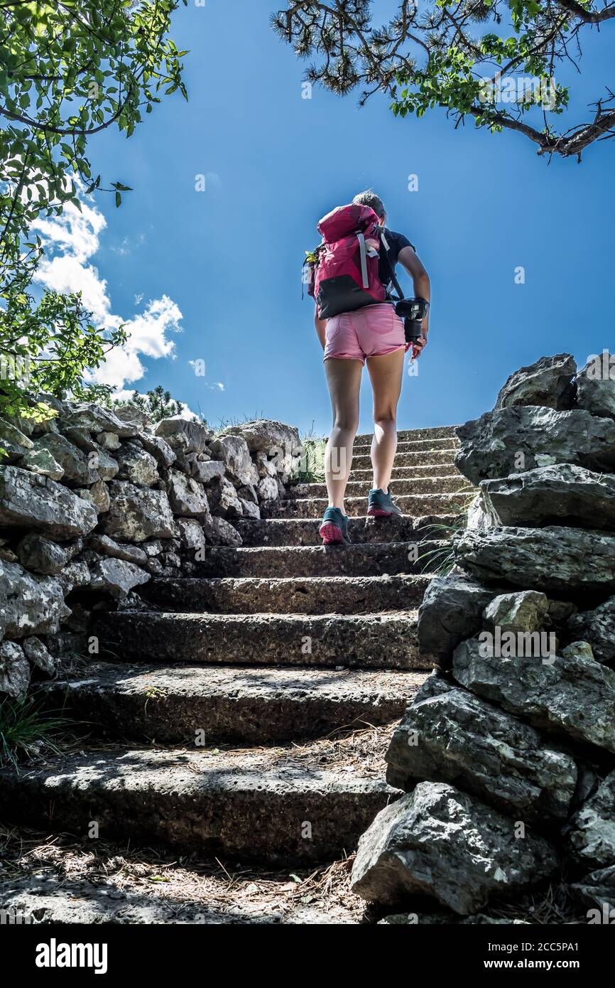 Young Woman Climbs Up Steep Outdoor Stairs With Rock Steps Stock Photo ...