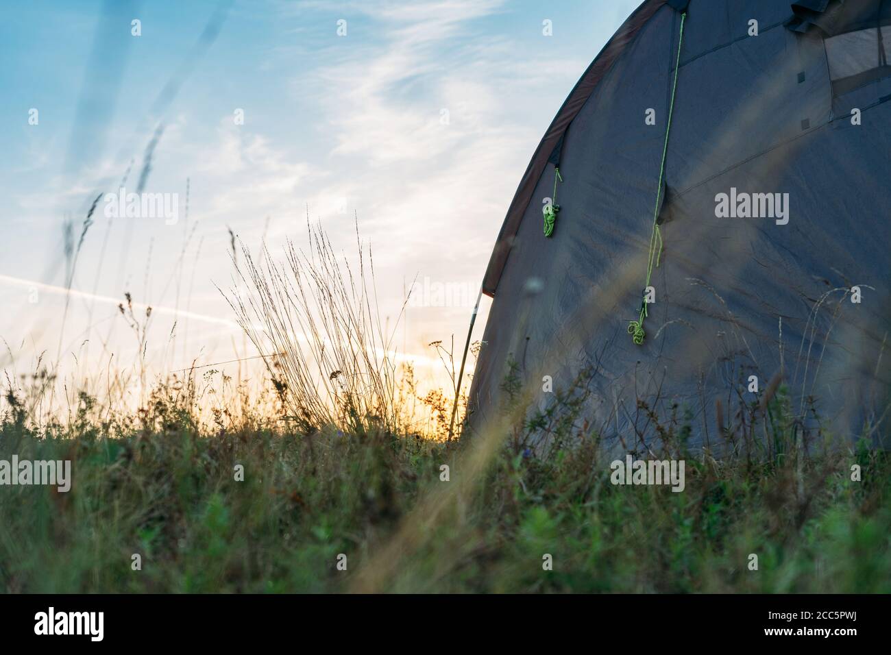 Grey tent on sunset landscape, beautiful sky background. Local tourism ...