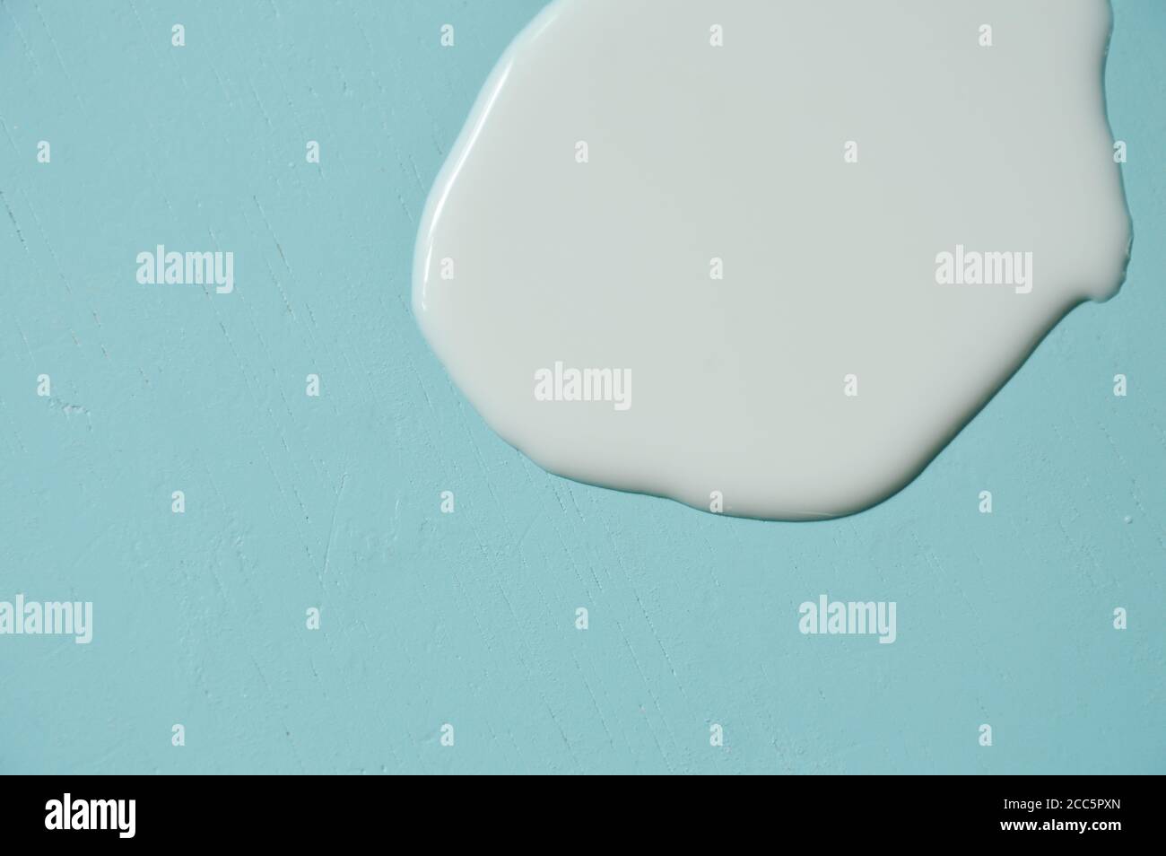 fresh white milk splatter on blue table background Stock Photo - Alamy