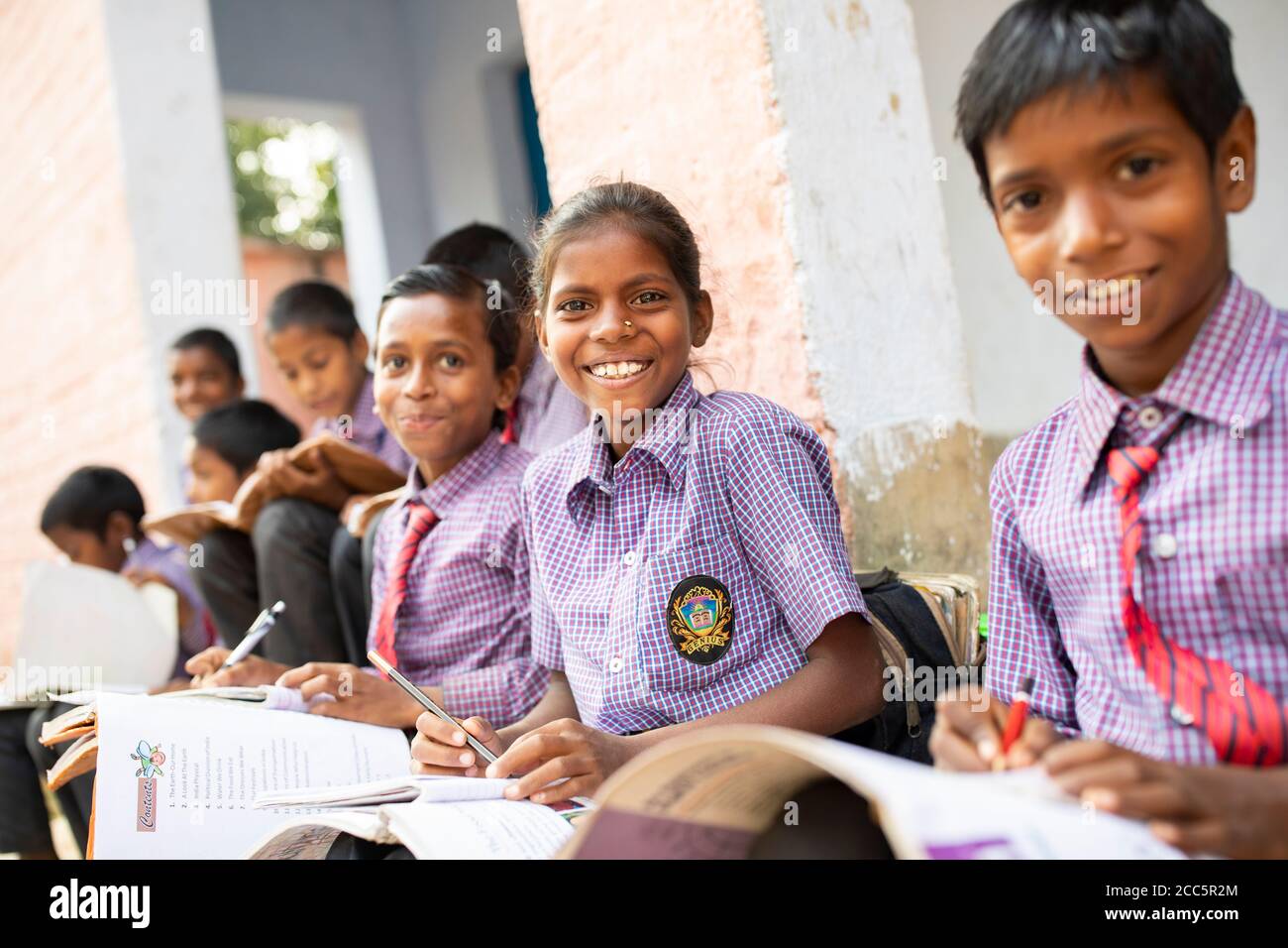 Primary school students in uniform attend school together and study ...