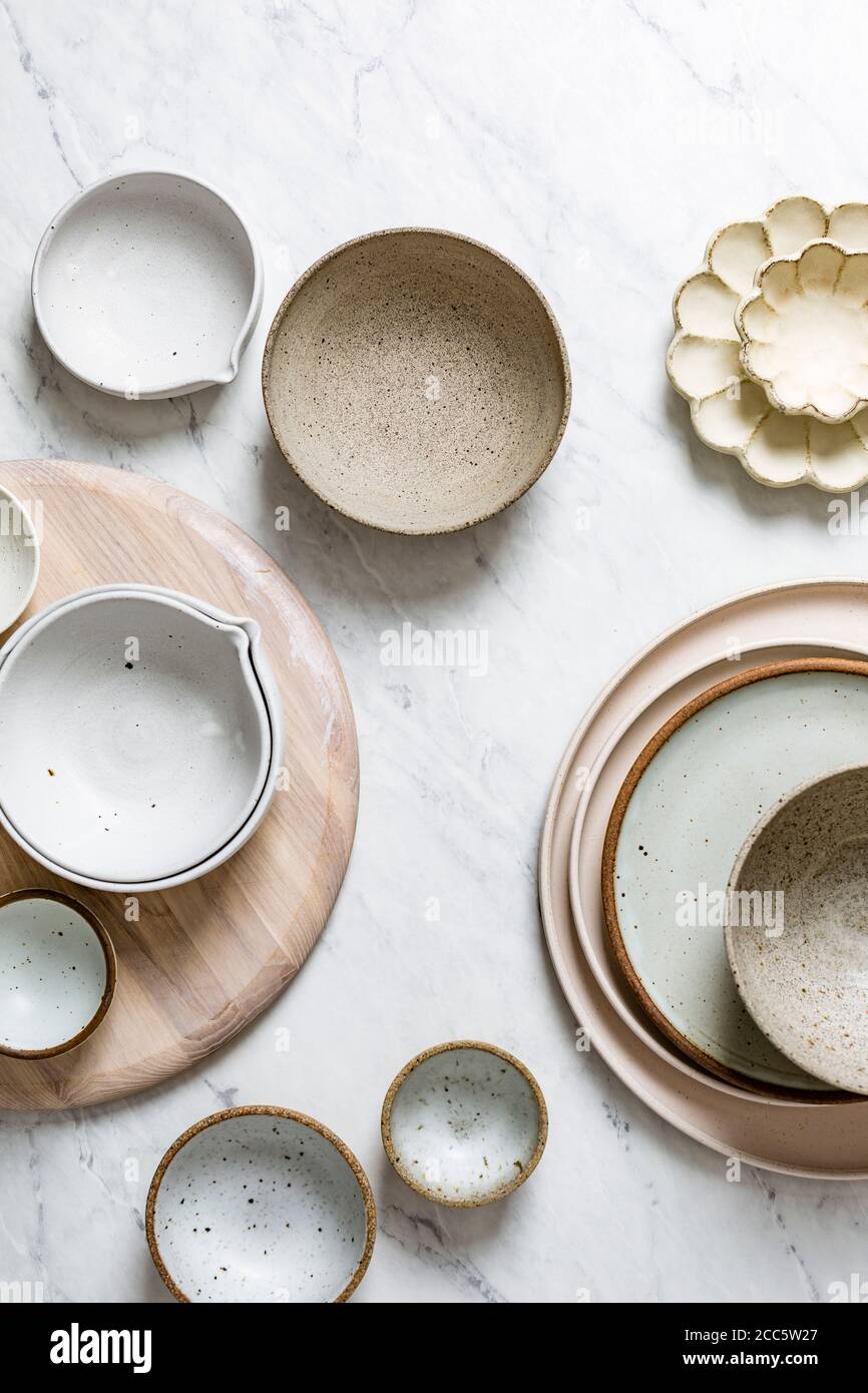 Ceramic bowls and plates on a marble work surface in a kitchen Stock ...