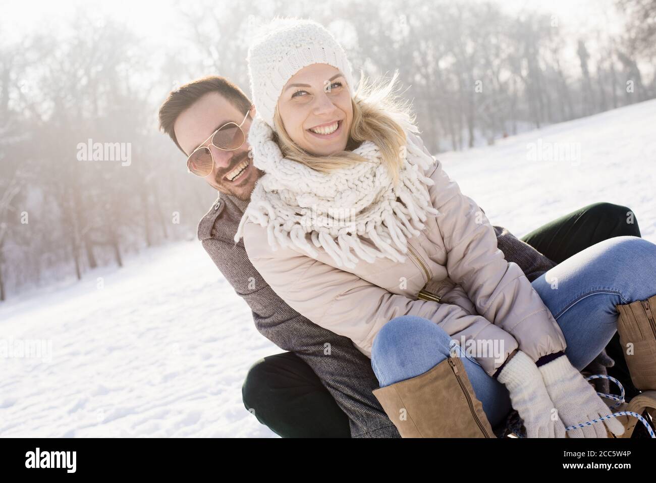 Happy couple enjoying the winter snow in the park on a beautiful winter ...