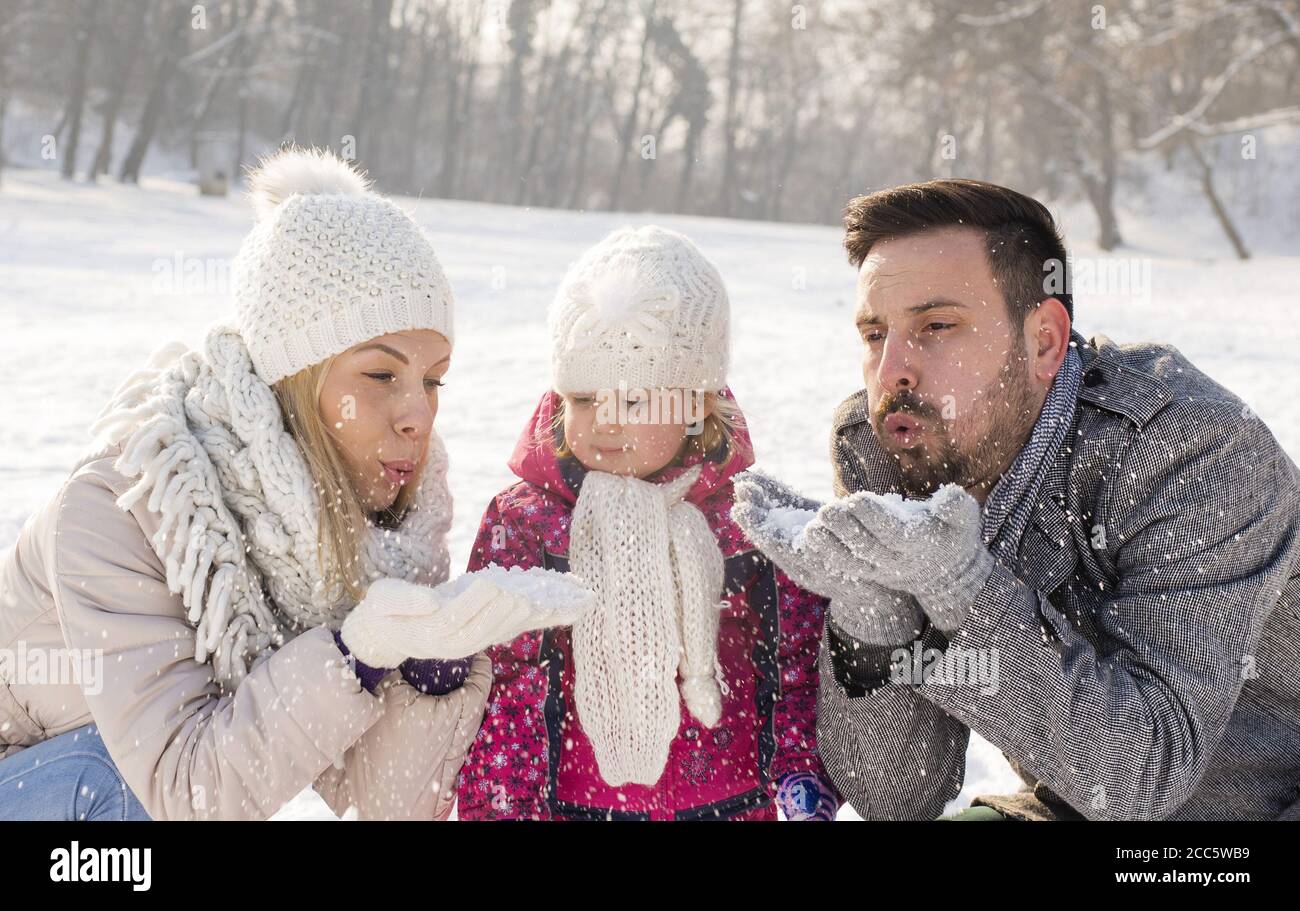 Happy family and their little daughter enjoying a beautiful and cold ...