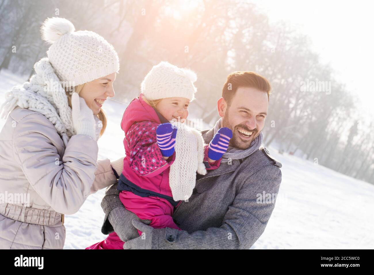 Happy family and their little daughter enjoying a beautiful and cold ...