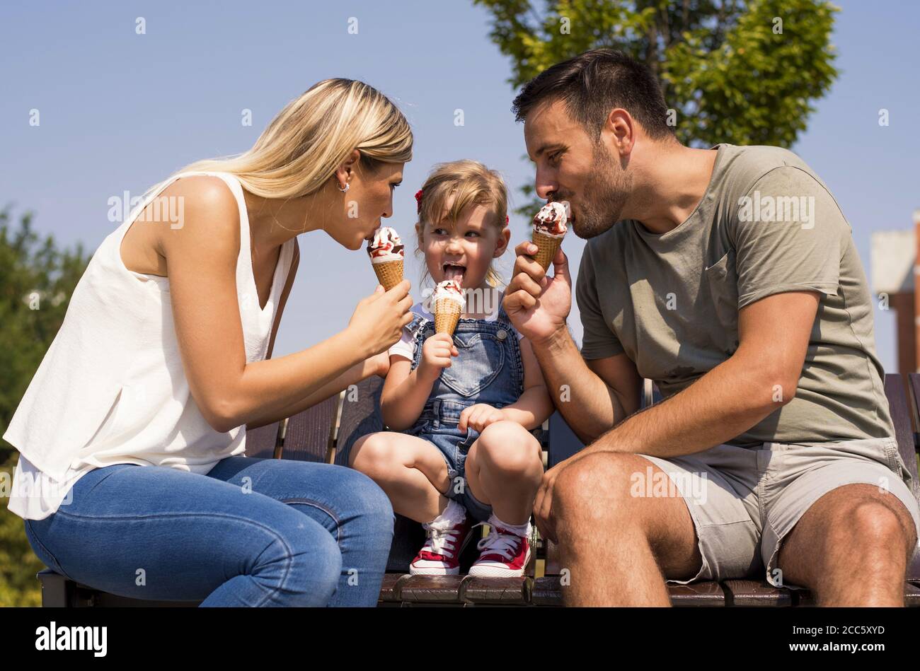 Selective focus shot of a young happy family eating ice cream with ...