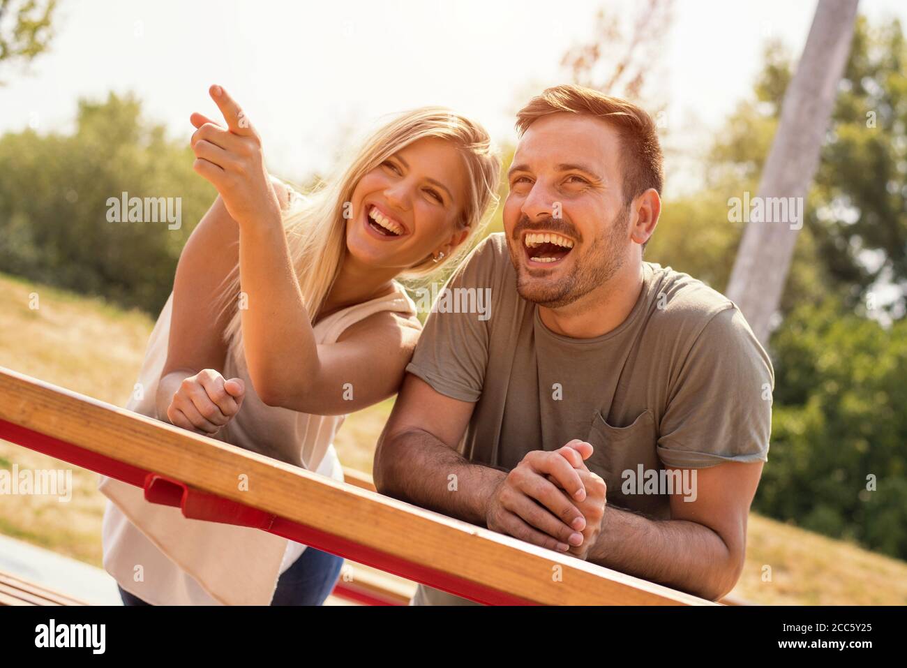 Low angle shot of a young happy white couple laughing Stock Photo - Alamy