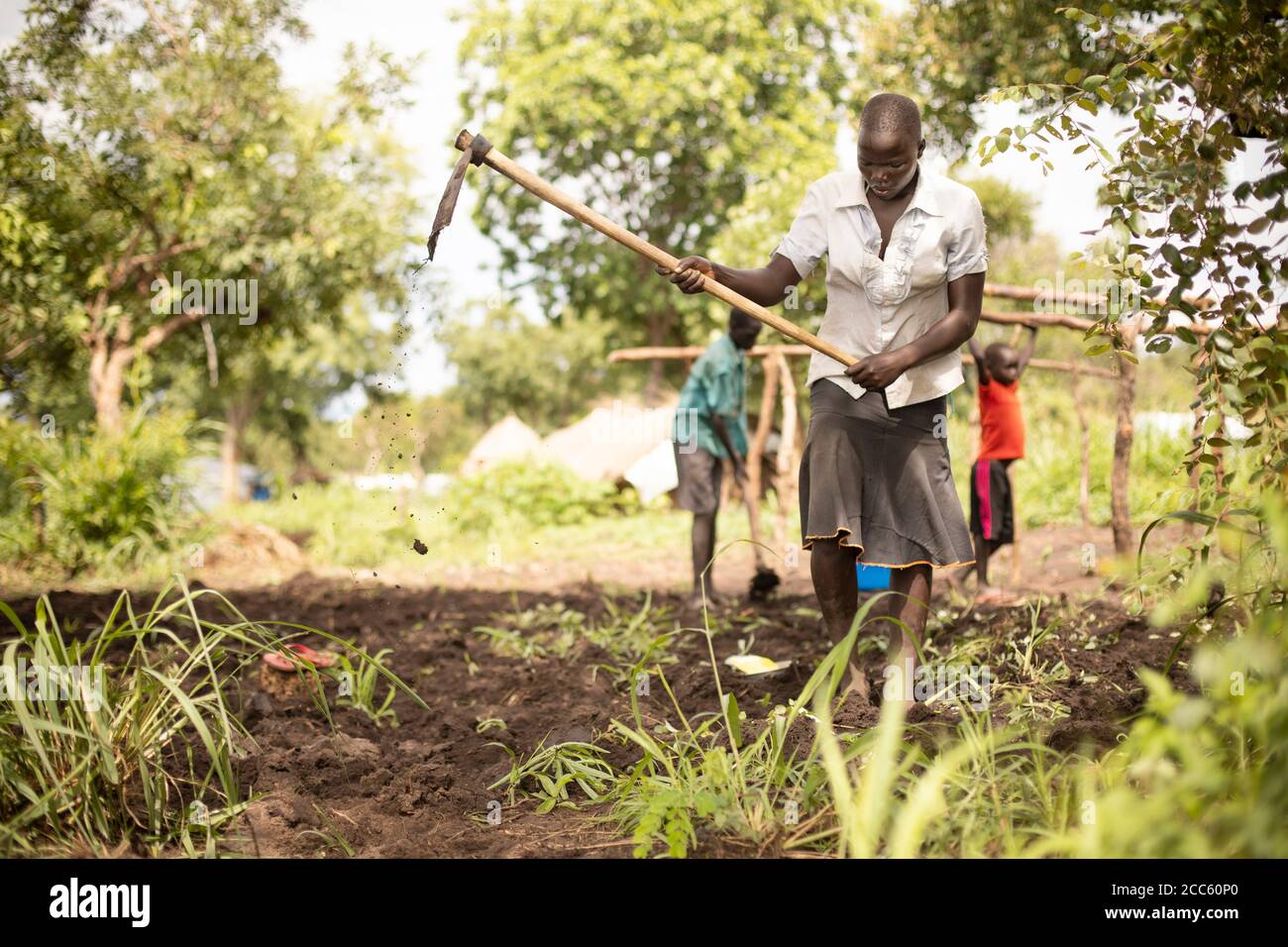 A female youth farms with a hoe on her family's small plot of land in ...