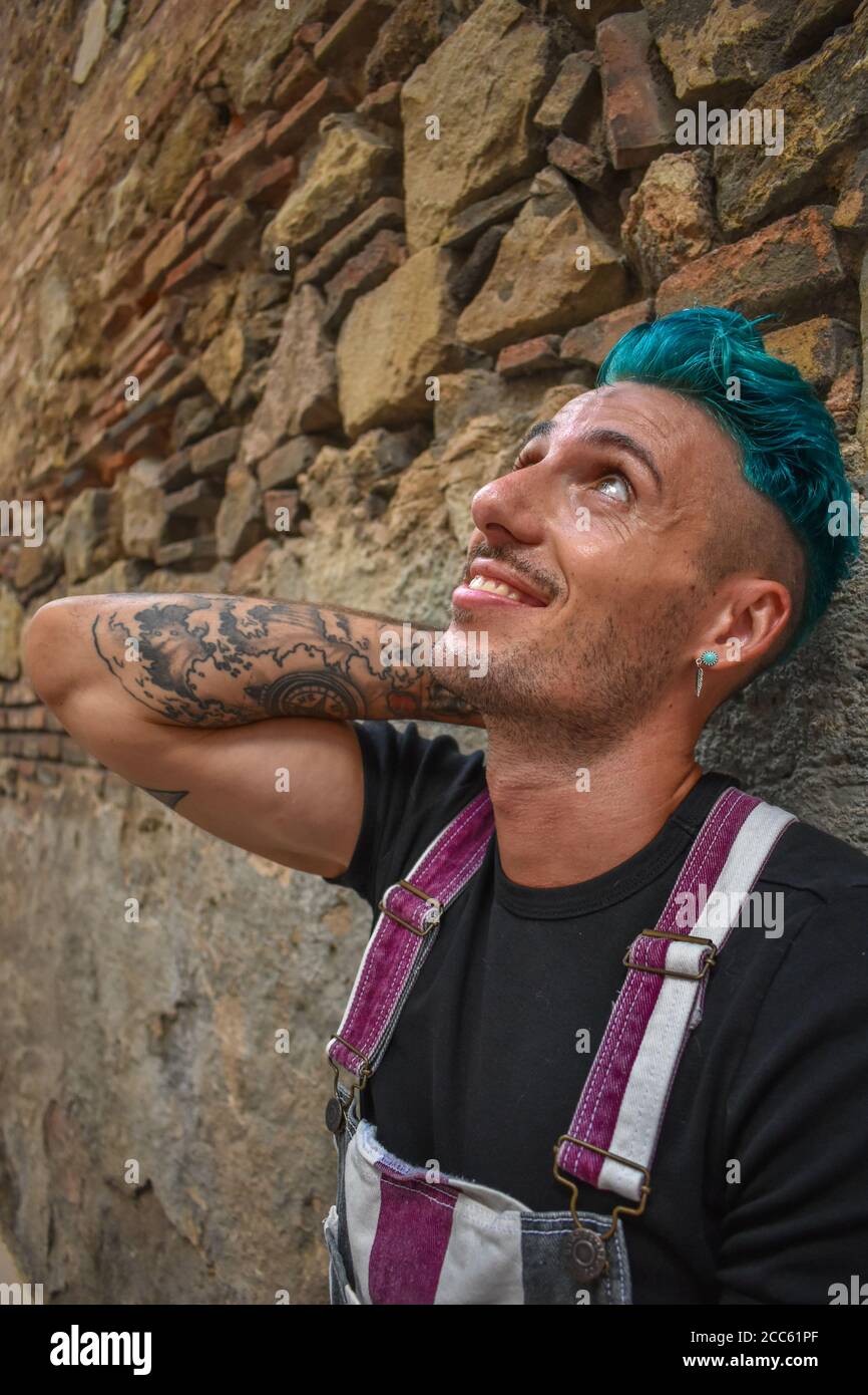 Vertical shot of attractive male posing against a wall Stock Photo - Alamy