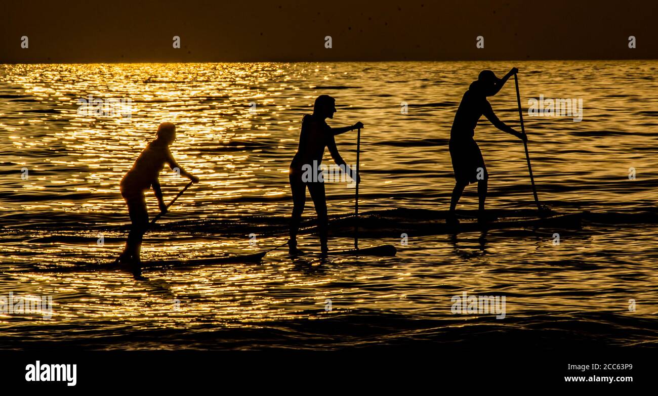 Silhouette of sup surfers in the Mediterranean sea at Sunset ...
