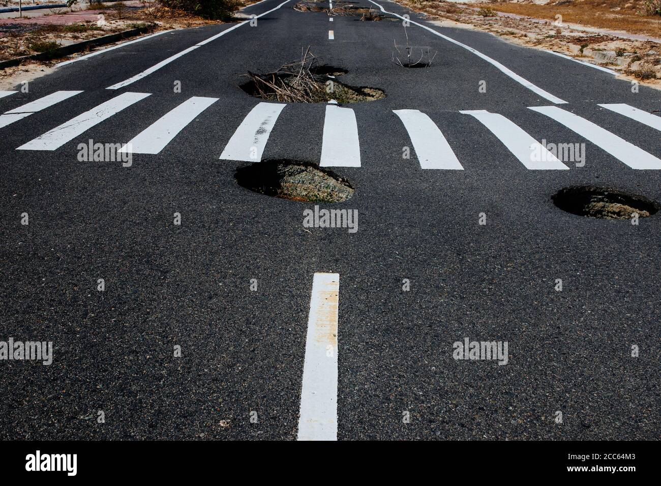 Deep holes, cracks on the asphalt road. Poor highway construction ...