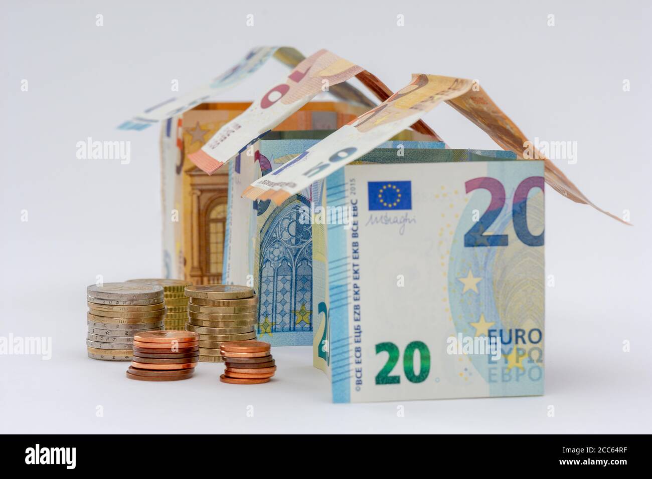 Houses made of 10, 20 and 50 euro banknotes, stacks of euro coins ...