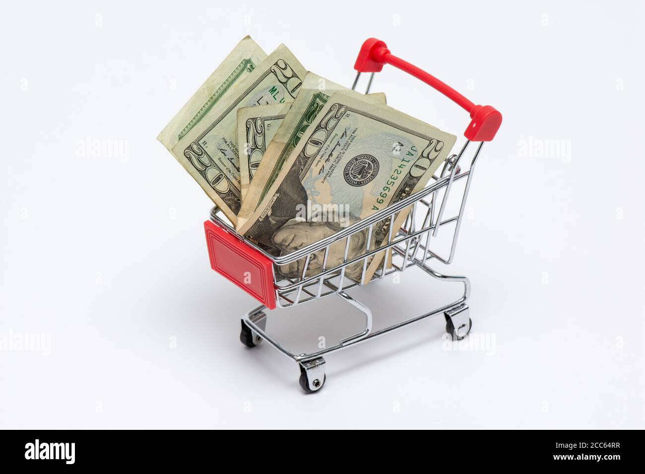 Shopping cart full of twenty dollar bank notes, white background ...