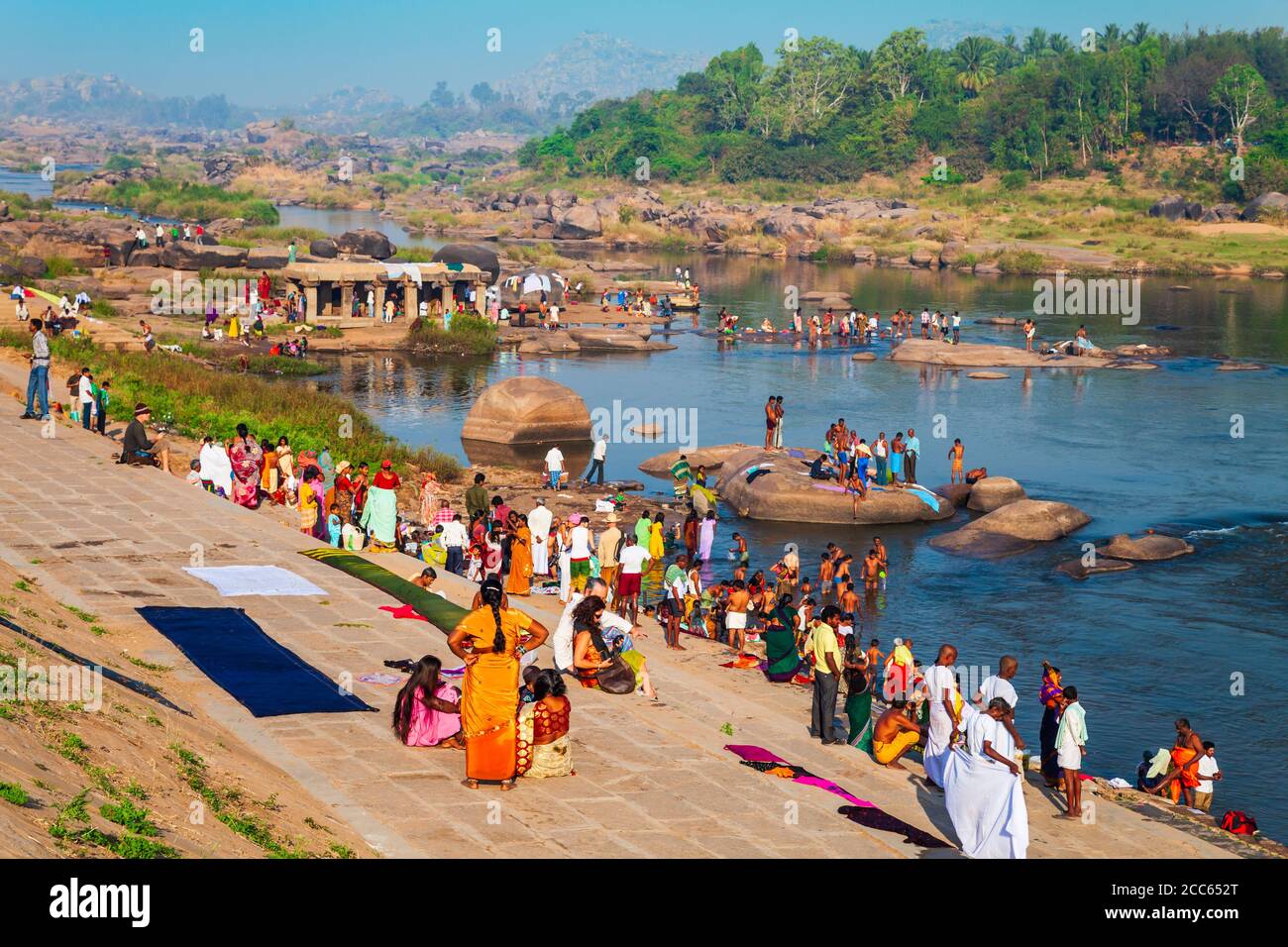 HAMPI, INDIA - FEBRUARY 20, 2012: Indian people bathing and washing ...