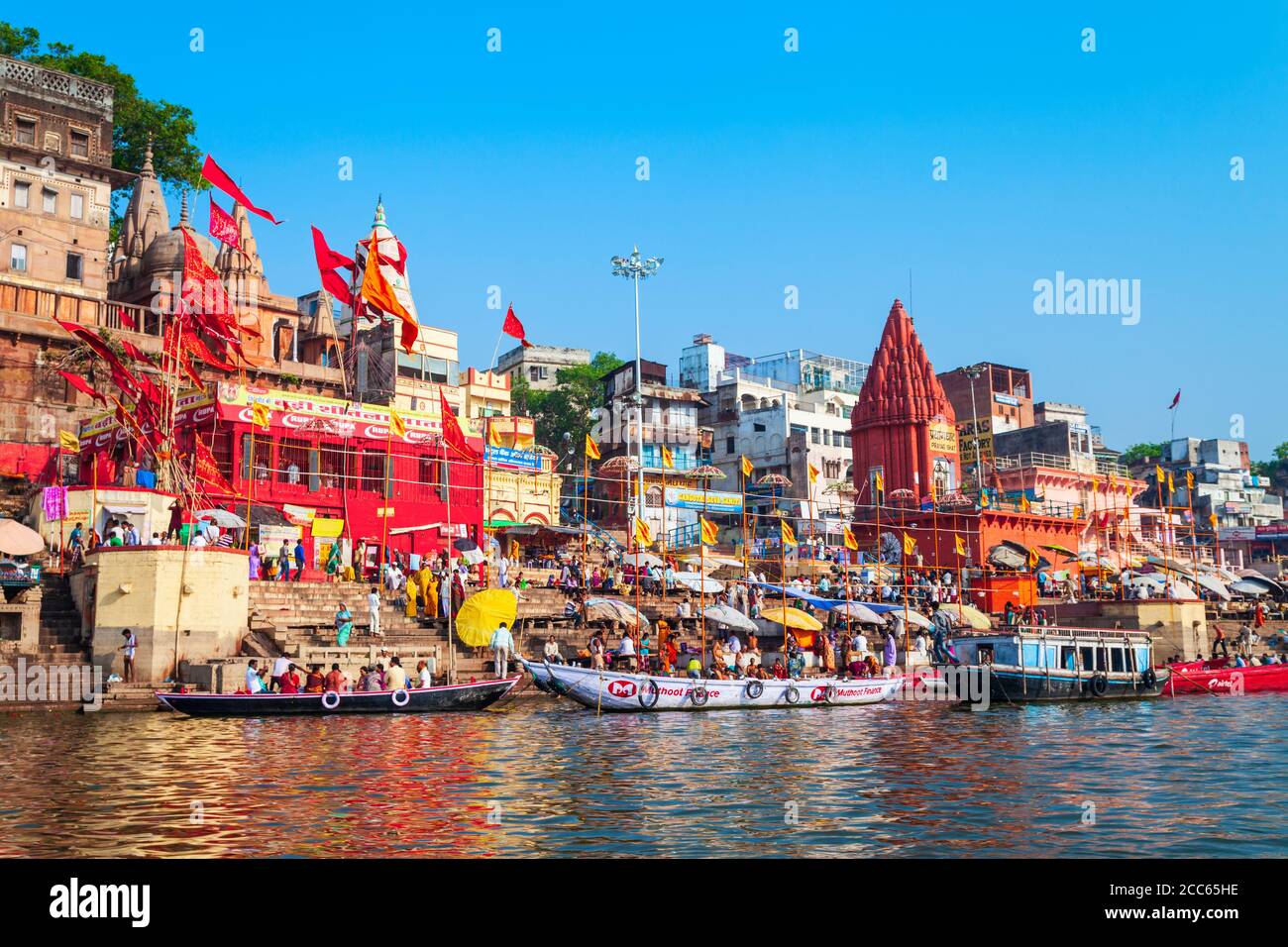 VARANASI, INDIA - APRIL 12, 2012: Colorful boats and Ganges river bank ...