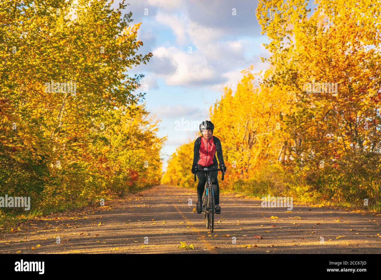 Bike autumn ride woman biking outdoors in fall nature foliage park ...