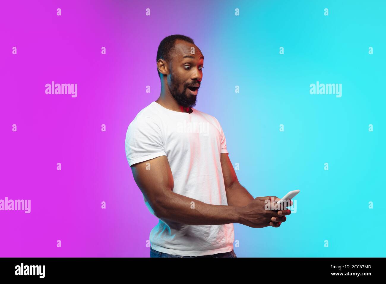 Scrolling phone. African-american young man's portrait on gradient ...