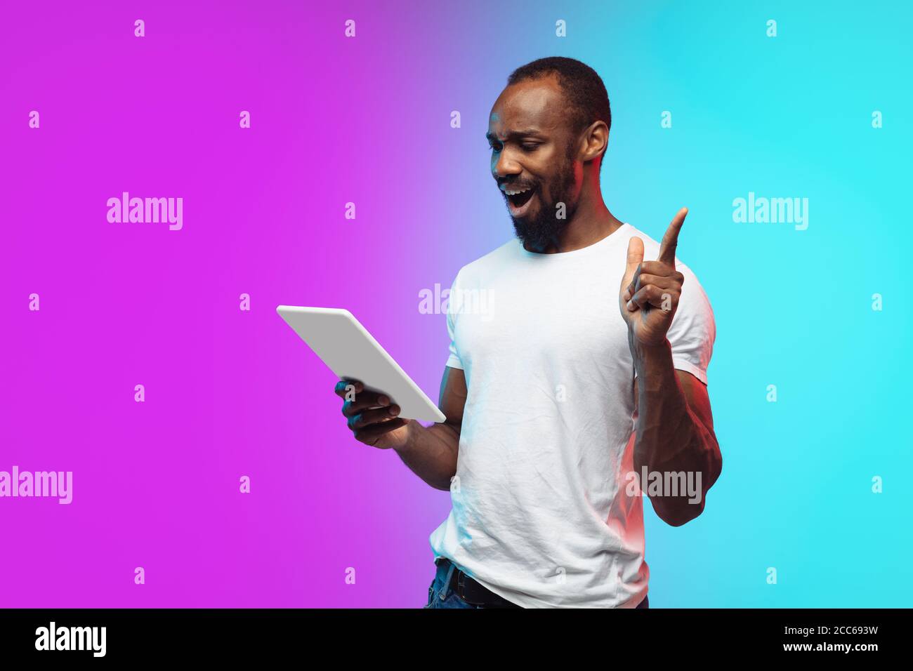 Scrolling tablet, idea. African-american young man's portrait on ...